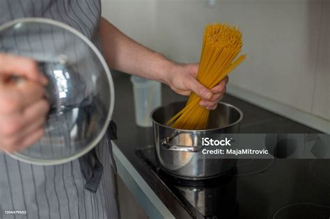 부엌에서 파스타를 준비하는 잘생긴 남자 맛있는 식사를 요리하는 남자 가정 생활에 대한 스톡 사진 및 기타 이미지 가정 생활