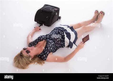 Delayed Airline Passenger Laying On The Floor Holding A Passport Stock