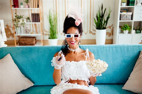 바로크 양식의 옷을 입은 우아한 여성이 쾌활한 미소를 지으며 실내에서 팝콘을 즐기고 있습니다 25 29세에 대한 스톡 사진 및 기타 이미지 Istock