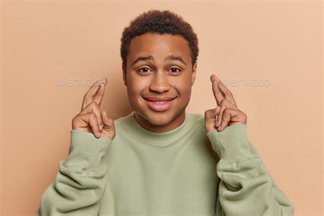 Horizontal Shot Of Handsome Dark Skinned Man Wishing Something Holds