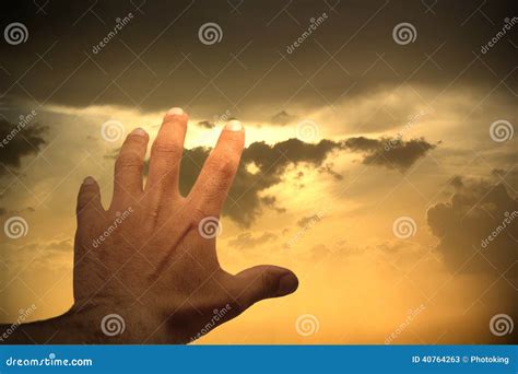Mano Que Alcanza Al Cielo De La Puesta Del Sol Imagen De Archivo