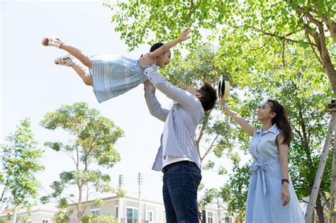 행복한 아시아 가족입니다 아버지는 자연 채광 배경과 집에 공원에서 하늘에 딸을 던져 복사 공간이 있는 가족 휴가 컨셉 3 명에