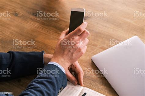 남성 손에 빈 검은 스크린 전화 집이나 사무실에서 작업 공간 백인 남자는 사무실 책상에서 일기에 계획하고 일정 을 기록했습니다