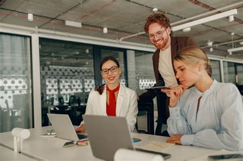 Engaging In Collaborative Teamwork Within A Modern Office Environment For Productivity And