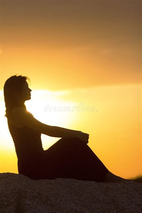 Silhouette De La Belle Fille Réfléchie Sasseyant Sur Le Sable Et