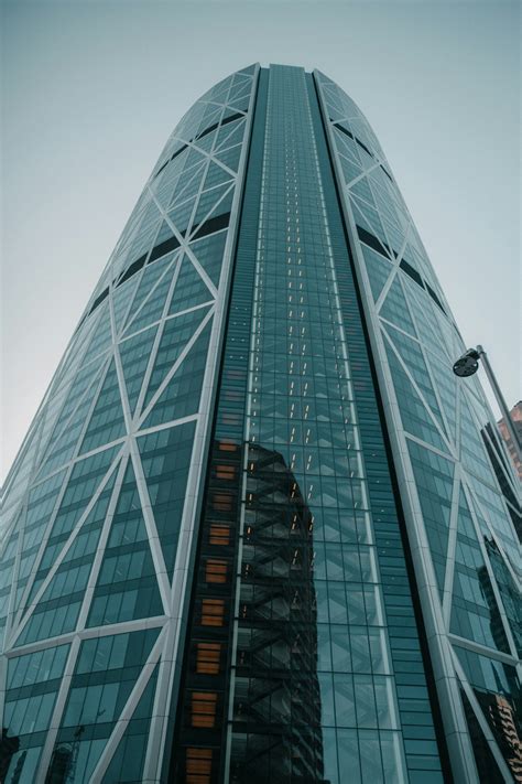 A Tall Glass Building With A Sky Background Photo Free City Image On