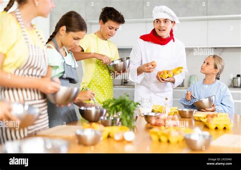Young Chef Giving Culinary Classes To Group Of Interested Tweens Stock