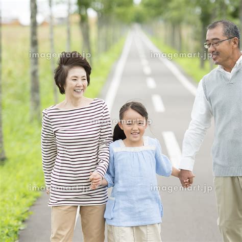 一本道で手をつなぐ祖父母と孫の写真素材 124219406 イメージマート