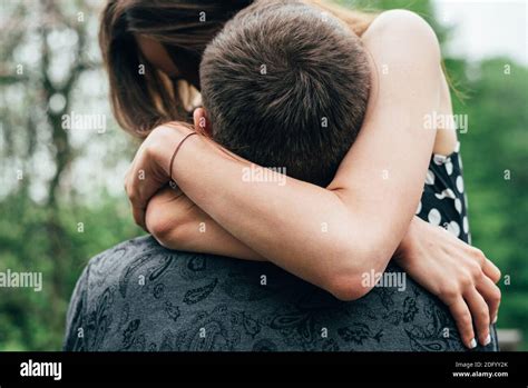 Girl Clasped Hands On The Neck Of Her Boyfriend Hugging Him Stock