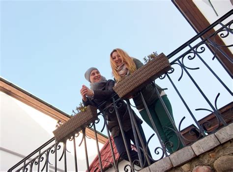 Парень и девушка стоят на балконе Опираются на перила и улыбаются Photo Image Photo