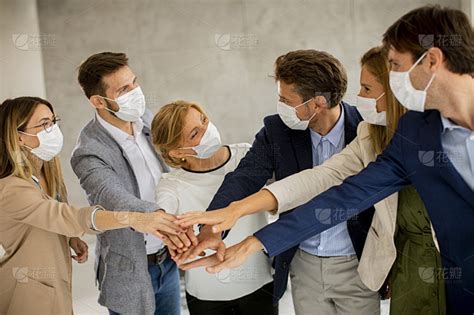 一群带着防护口罩的商人手拉着手