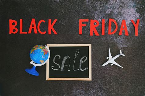 블랙 프라이데이 컨셉 비문 검은 금요일 장난감 비행기 작은 지구 검은 배경에 단어 판매와 보드 쓰기 보드 공간 상단 보기 플랫 레이를 복사합니다 창조적 인 휴일 여행 개념