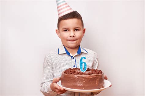 숫자 6의 형태로 촛불이 달린 생일 케이크를 들고 있는 쾌활한 소년 생일 축하 개념입니다 6에 대한 스톡 사진 및 기타 이미지