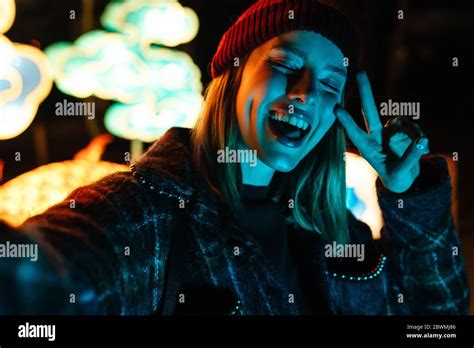 Photo Of Joyful Woman Gesturing Peace Sign And Taking Selfie Photo