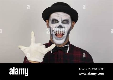 Terrible Man In Clown Makeup Shows The Sign Of Rock With His Hand A