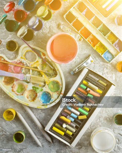회색 콘크리트 배경에 그림을 그리는 예술적인 도구입니다 팔레트 구 아 슈 오일 페인트 브러시 컬러 크레용 파스텔 컬러 색연필