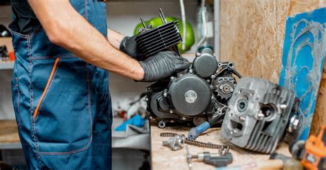 작업장의 작업 테이블에서 수리하는 동안 오토바이 엔진을 분해하는 작업자 얼굴 없이 클로즈업 사진 Unsplash의 우크라이나 이미지