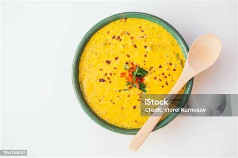 녹지와 야채와 뜨거운 크림 맛 있는 수프 그릇에 나무 숟가락 흰색 배경 위에 고립 코코넛 카레 스프 신선한 Disn 건강 한