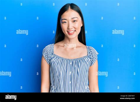Young Chinese Woman Wearing Casual Striped T Shirt With A Happy And