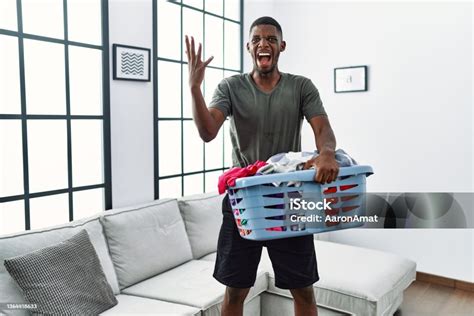행복한 미소와 승자 표정으로 승리를 축하하는 바구니를 들고 세탁을하는 젊은 아프리카계 미국인 남자 남자에 대한 스톡 사진 및 기타 이미지 Istock