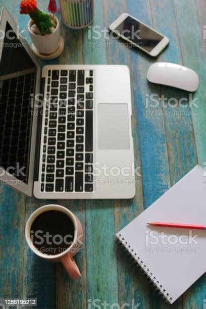 블랙 커피 펜 홀더 화분선 스마트 폰 노트 패드 연필 및 무선 마우스 푸른 나무 곡물 배경 전경에 초점을 맞춘 커피 컵으로