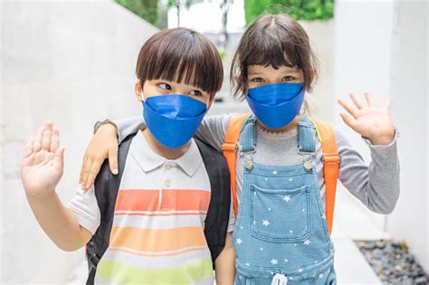 학교 배낭보호 마스크를 쓴 여동생과 동생 학교 가방을 들고 있는 초등학생의 모습 2명에 대한 스톡 사진 및 기타 이미지 2명