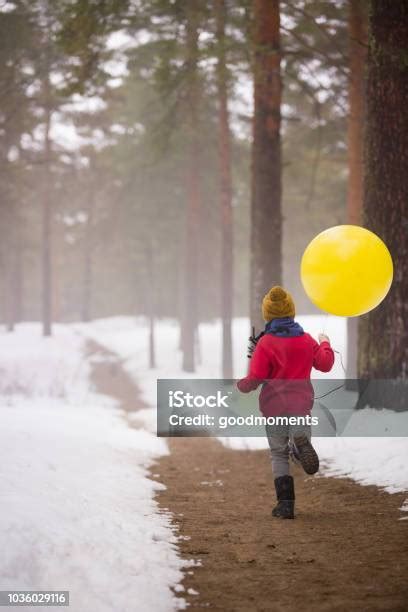 청바지에 빨간색 스웨터 겨울 숲에서 실행 하 고 큰 노란 풍선을 들고 행복 한 작은 소년 생일 소년 풍선입니다 생일 축 하입니다 풍선 소년을 실행 겨울에 대한 스톡 사진 및