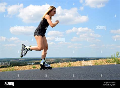 Teenage Girl On Roller Skates At Summer Inline Skating On The Road