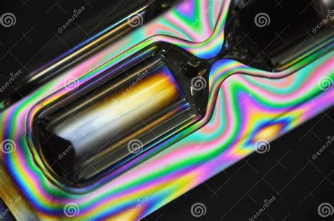 A Colorful Rainbow Hourglass Measuring Time Against A Black Background
