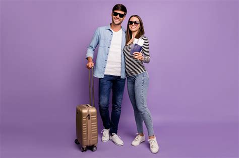 2 인 커플 남자 여자 산책 공항 등록 티켓 여권 수하물 휴가 시간 착용 세련 된 캐주얼 옷 고립 된 파스텔 보라색 색 배경의 전체 길이 사진 2명에 대한 스톡 사진 및