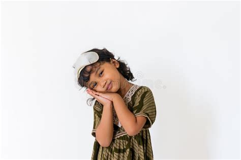 A Little Asian Girl Wearing Pajamas And An Eye Mask Poses Before Going