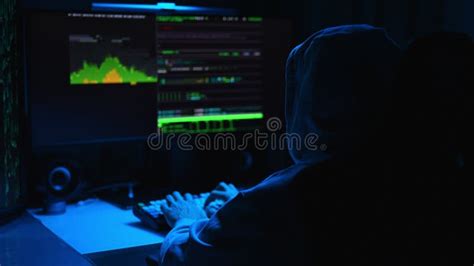 Rear View Of Hacker Man In Hoodie Typing On Keyboard Breaking Password