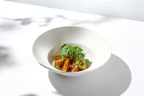 화이트 플레이트에 중국 스타일의 바삭 바삭한 가지 여름 메뉴에 바삭한 가지 샐러드 아시아 전채 고수풀 잎으로 구운 Aubergine 비건 음식 미적 채소 메뉴 가지 채소에