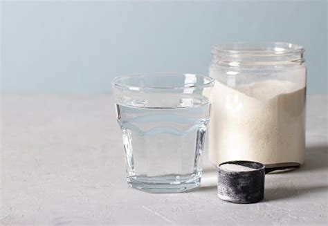 물 한 잔 항아리에 콜라겐 분말 및 텍스트에 대 한 장소와 밝은 파란색 배경에 분말 측정 숟가락 가루로 빻은에 대한 스톡 사진