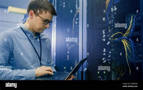 In Data Center It Engineer Stands Before Working Server Rack Doing Routine Maintenance Check And