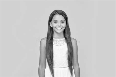 Cute Teen Girl In White Dress Has Long Hair On Yellow Background Stock
