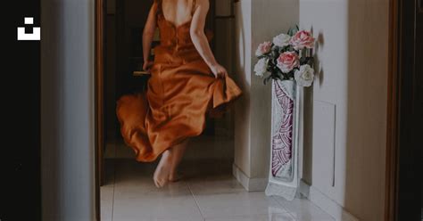 Mujer Con Vestido Naranja Sentada Sobre Baldosas De Cerámica Blanca