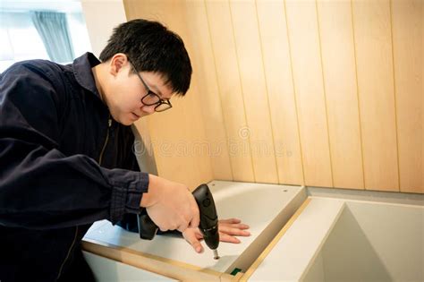 Asian Male Furniture Assembler Installing Kitchen Counter Stock Image