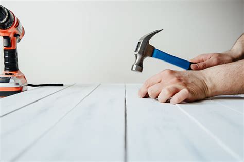 한 남자가 나무 판에 망치로 못을 박았다 Diy의 개념과 새로운 것들의 개조 망치에 대한 스톡 사진 및 기타 이미지 망치