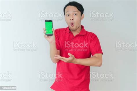 스튜디오 배경에서 스마트 폰의 녹색 화면을 표시 할 때 미소 젊은 아시아 남자의 와우 얼굴 25 29세에 대한 스톡 사진 및 기타 이미지 25 29세 T 셔츠