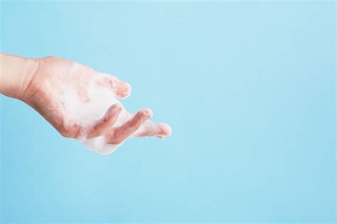 흰색 비누 거품으로 덮인 손 손씻기 및 위생 정화 및 목욕 시간 청결과 바디 케어 컨셉 오른쪽에 있는 공간을 복사합니다
