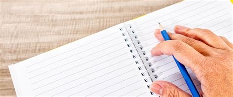 Premium Photo Close Up Of Female Hand Writing In A Notebook On A