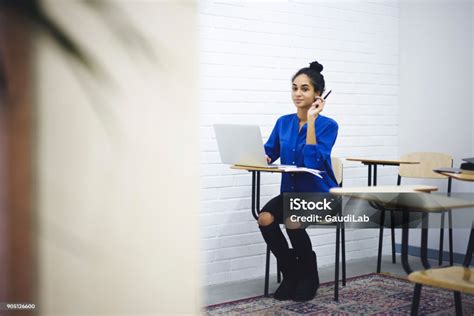 전체 길이 가제트와 함께 교실에 앉아 새 정보를 가져오는 동안 카메라를 보고 하는 예쁜 여자의 초상화 귀여운 재능 있는 학생 대학 세미나 노트북 컴퓨터를 사용 하 여 준비