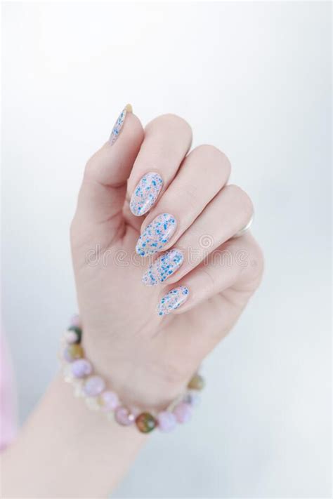 Female Hands With Long Nails And A Bottle Of Light Pink Color Nail