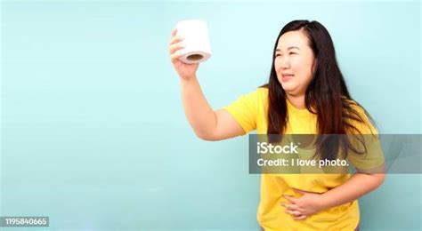 설사 증상을 가진 아시아 여자 스튜디오에서 파란색 배경에 고립 된 설사로 고통받는 아픈 여성 가정의 방에 대한 스톡 사진 및