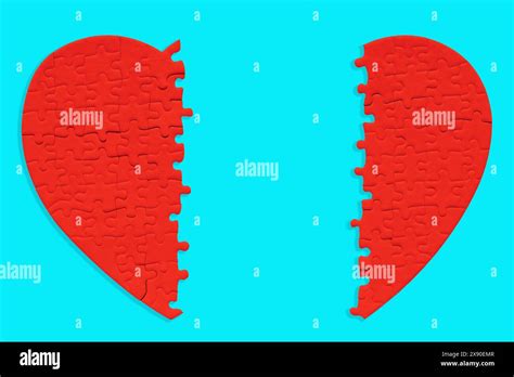 Two Parts Of A Red Heart Shaped Puzzle Rest Side By Side On A Blue