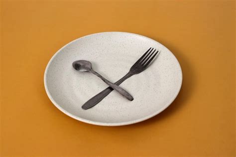 Premium Photo Empty Plate Spoon And Fork On Yellow