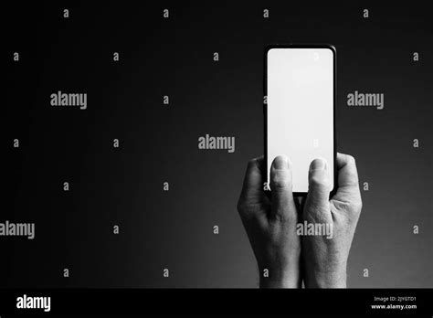 Black And White Image Of Mans Hands Holding Smart Phone And Texting