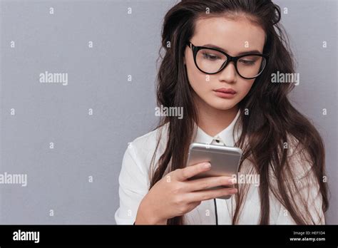 Serious Pretty Asian Woman In Glasses Writing Message On Phone Front