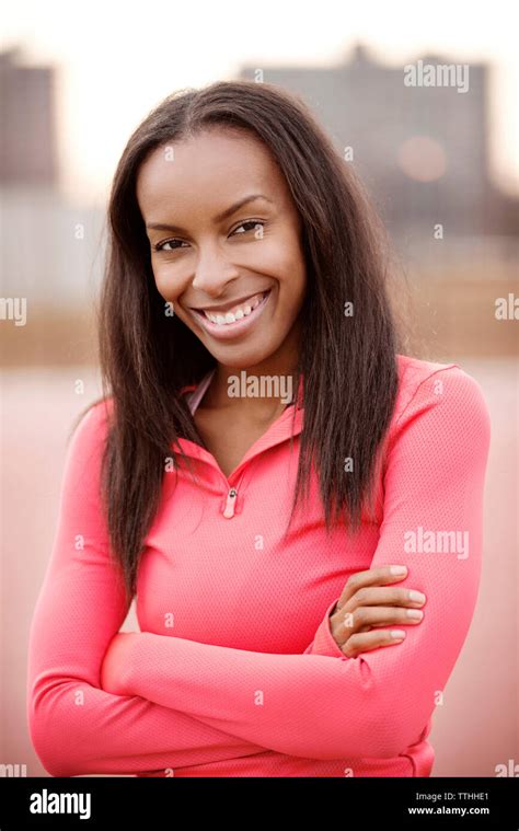 Portrait Of Confident Smiling Woman Standing With Arms Crossed Stock Photo Alamy